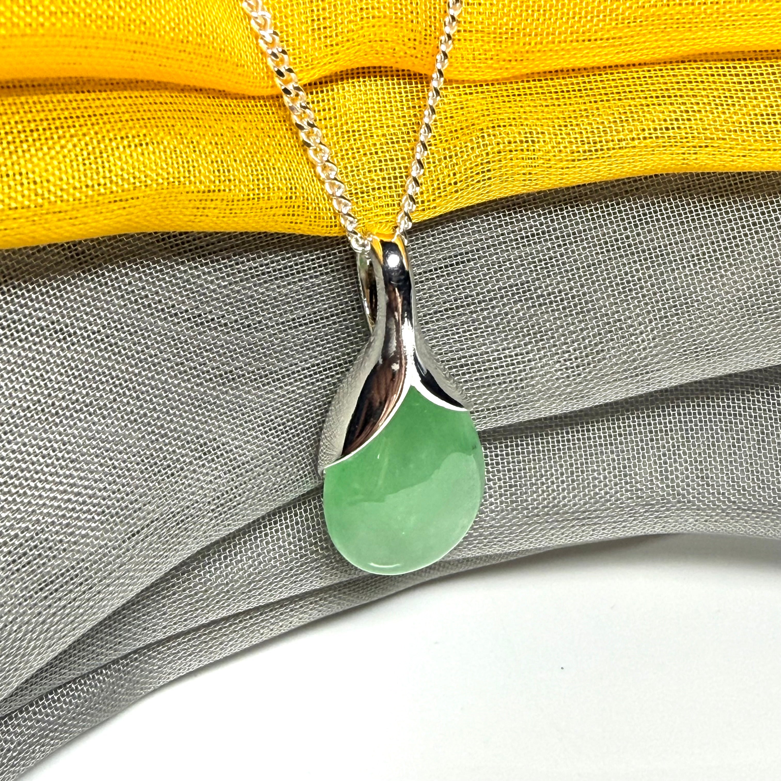 A real green jade necklace in a teardrop or pear shape, a traditional ...