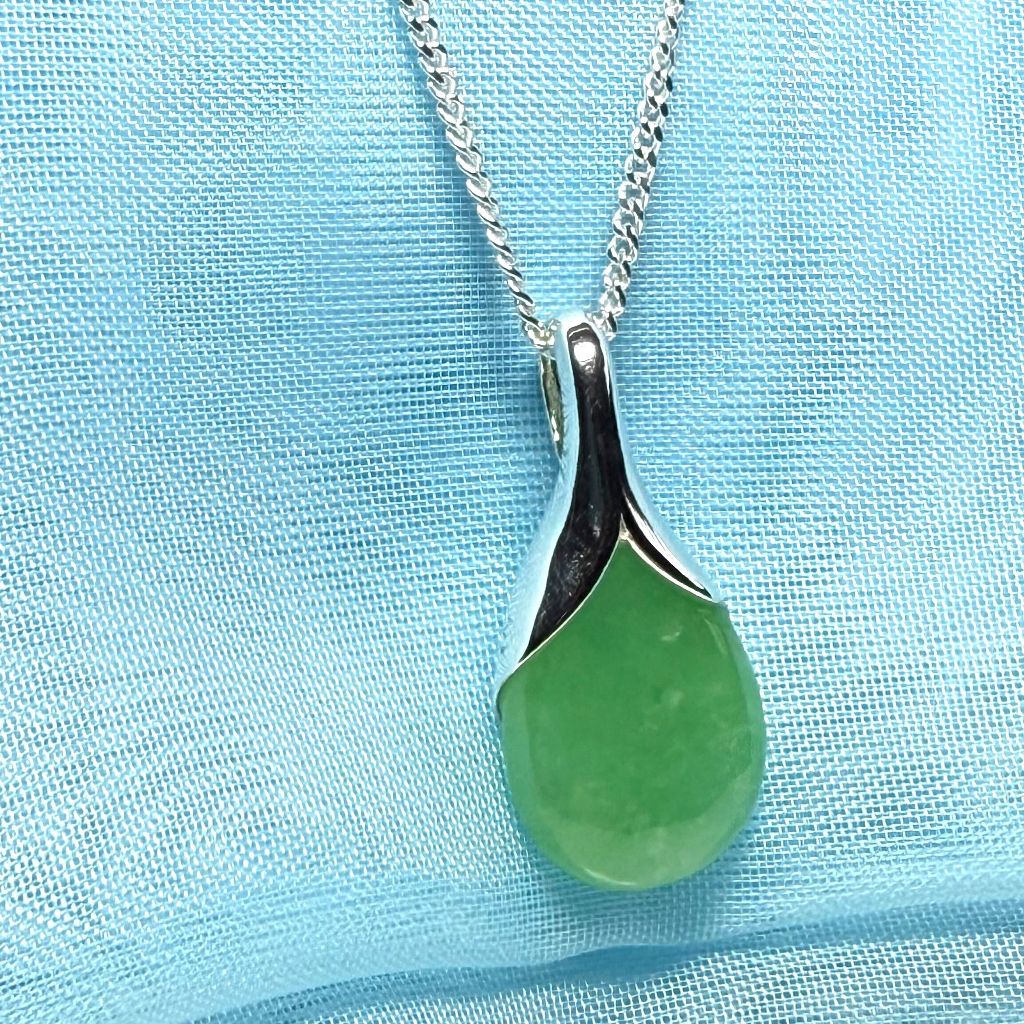 A real jade pendant in a teardrop shape or pear shaped designed green ...